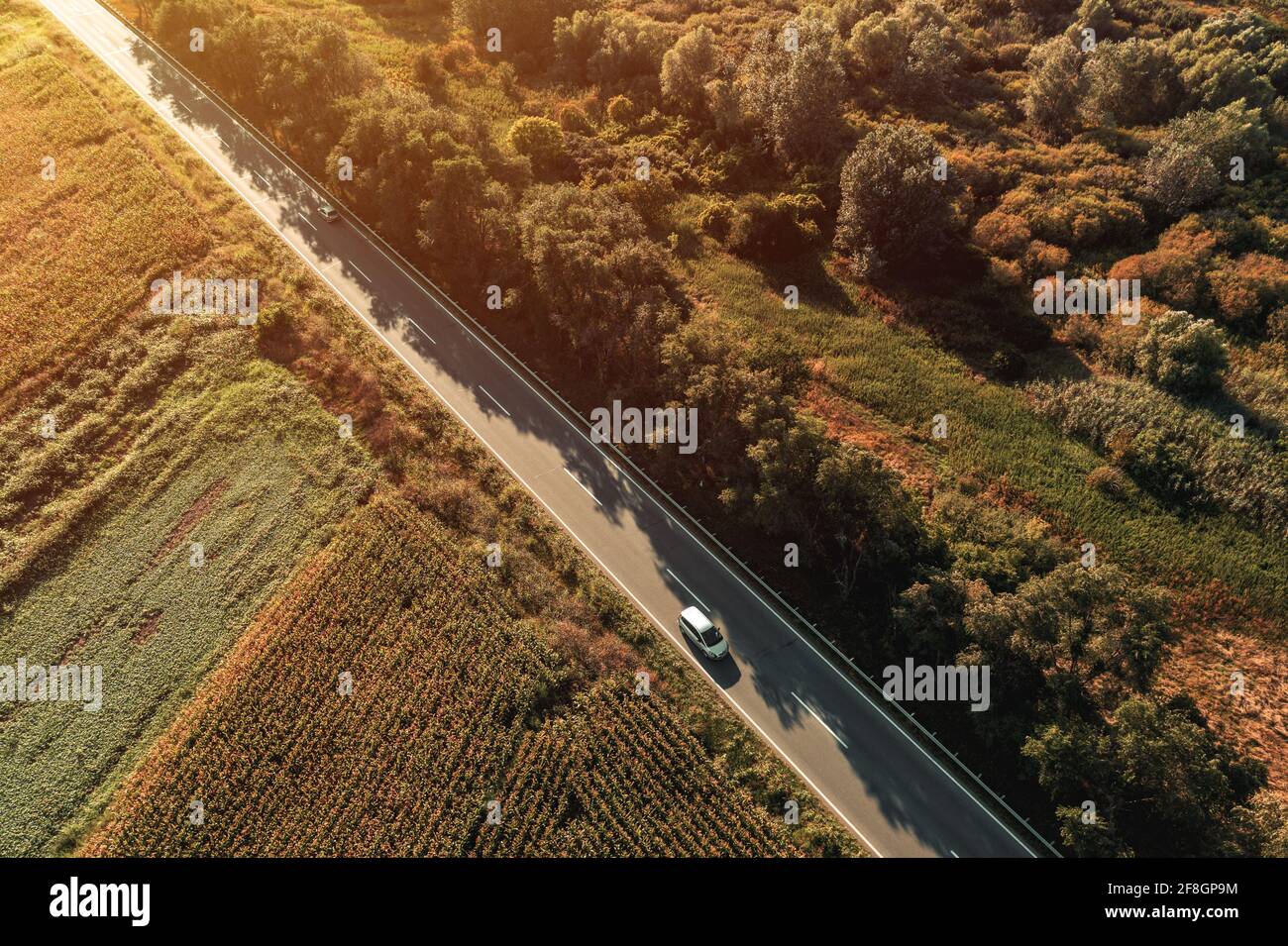 Aerial photography of cars driving on road through plain countryside ...
