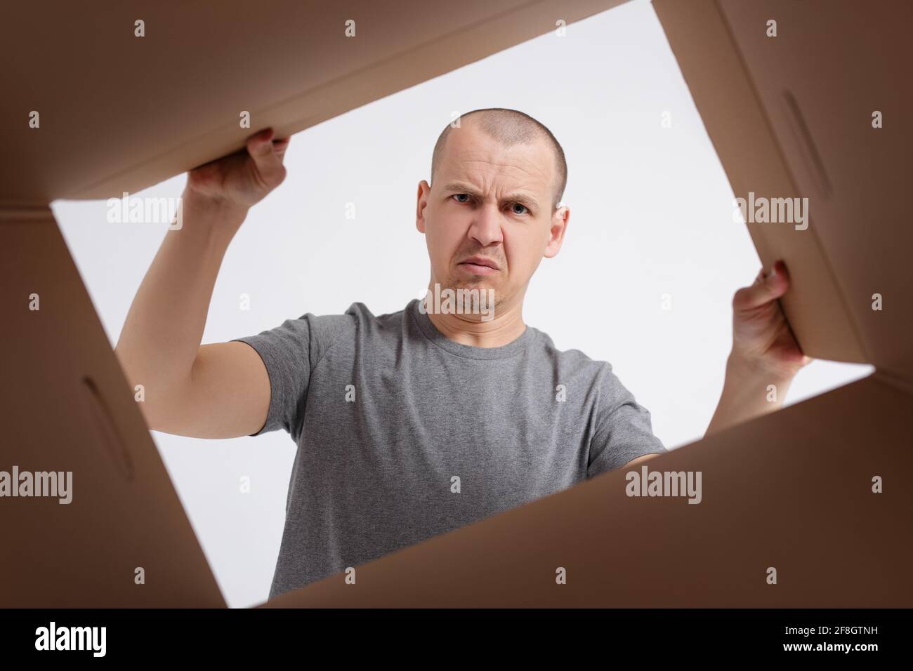 young disappointed man looking inside the box - view from the box Stock ...