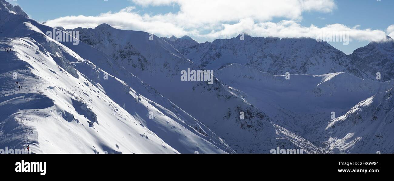 Picturesque snow-covered mountains against blue sky with white clouds ...