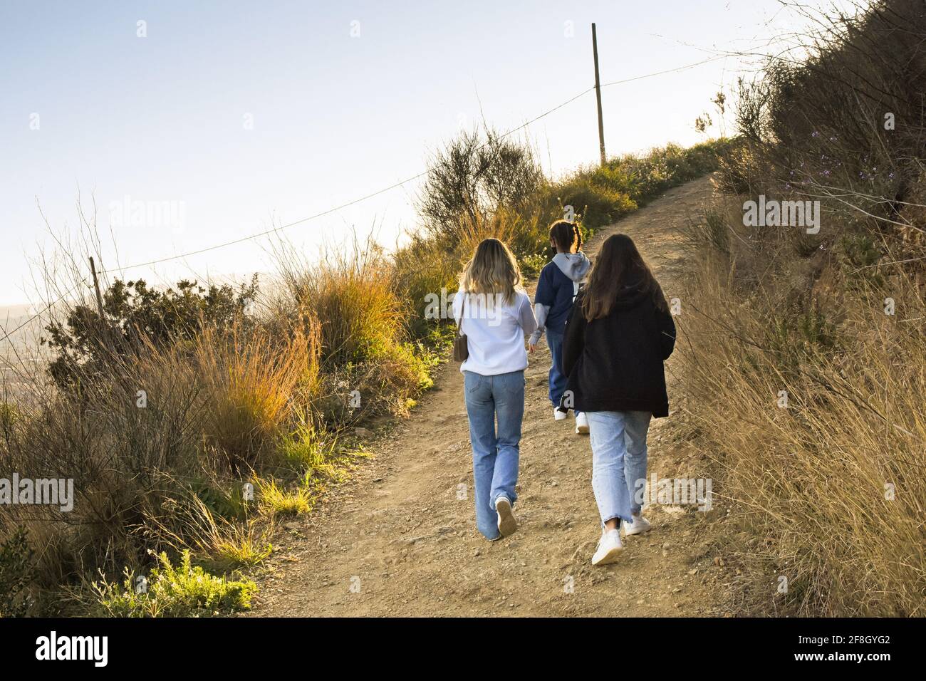 Rear view of teenagers girls walking in a path outdoors Stock Photo - Alamy