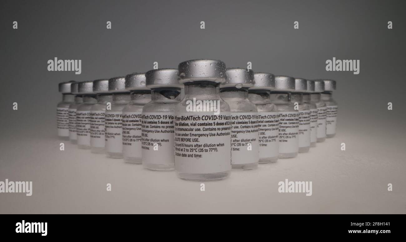 original comirnaty vaccine vial arranged in a group in front of a white ...