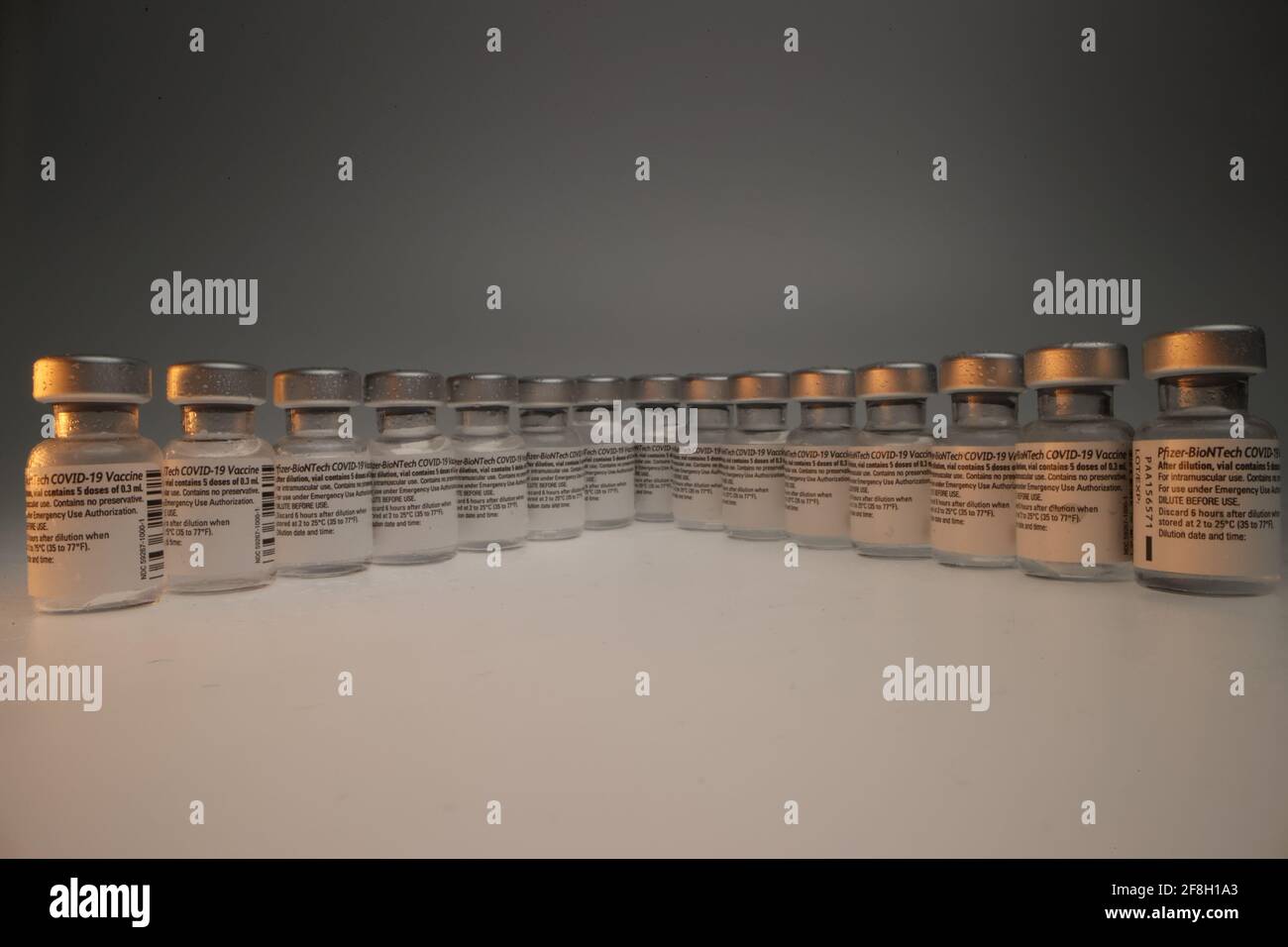 original comirnaty vaccine vial arranged in a group in front of a white ...