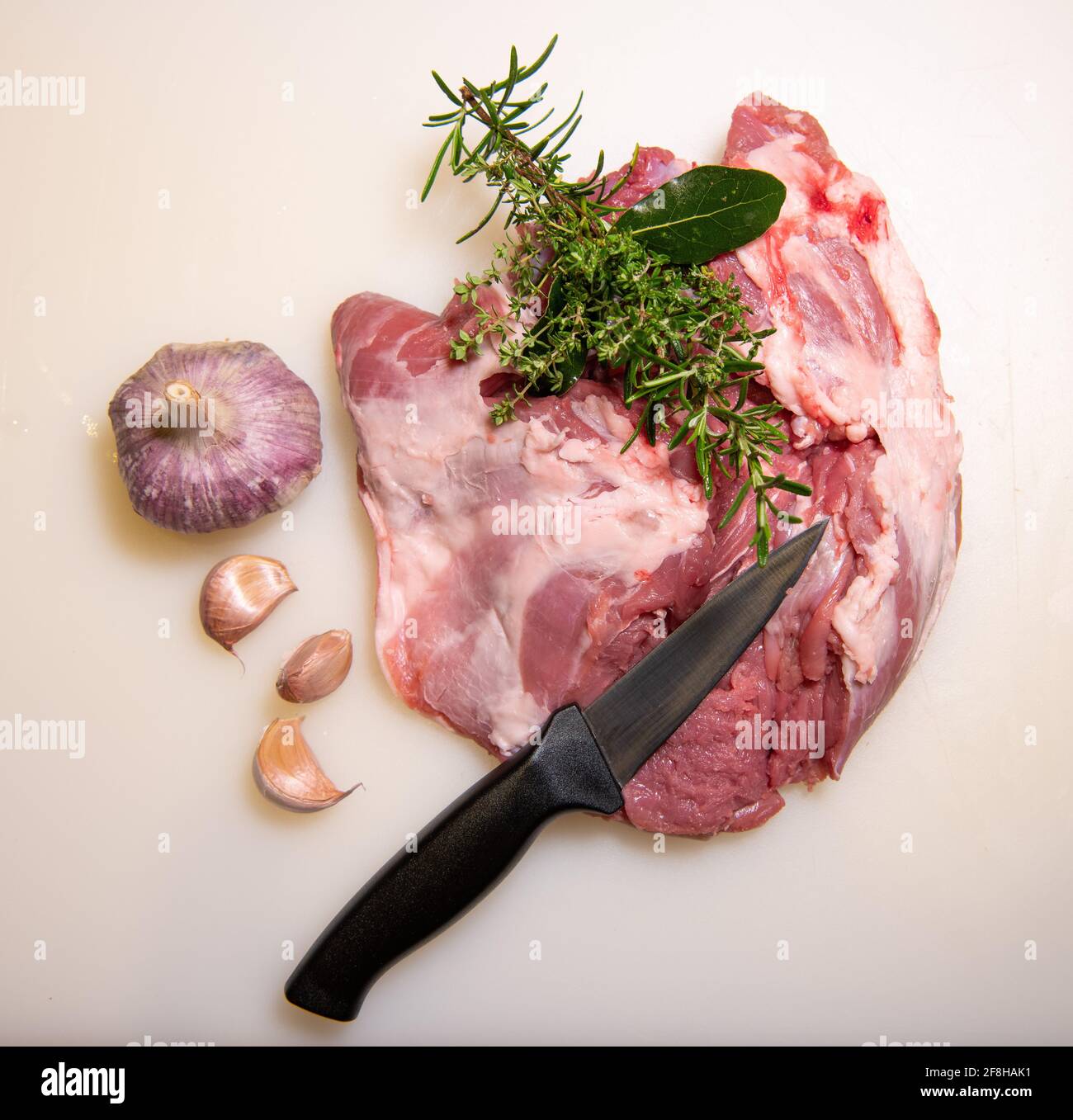 Boning a shoulder of lamb leg meat on a wooden tray, white background ...