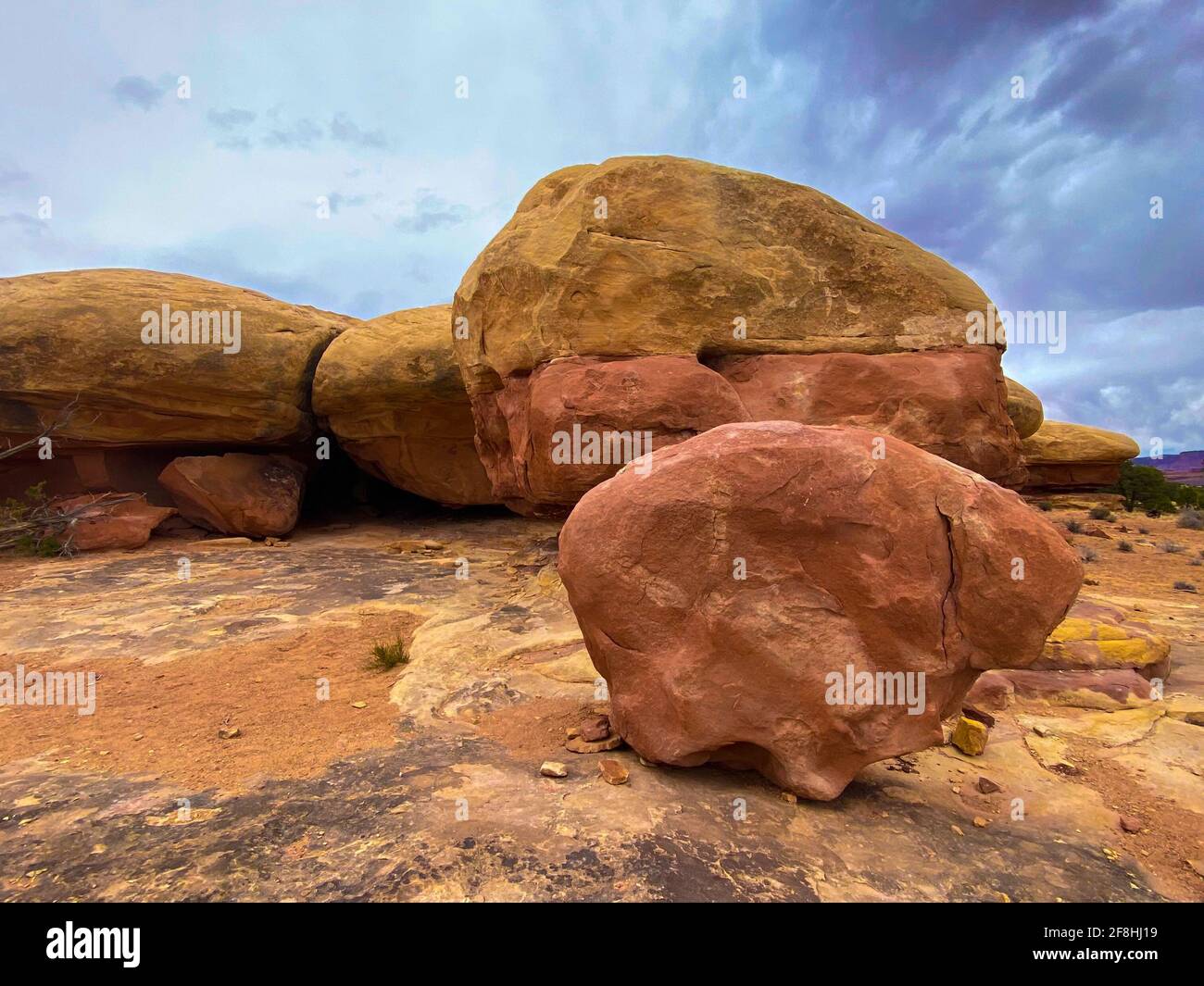 Desert with yellow soil and big stones under a cloudy sky Stock Photo - Alamy