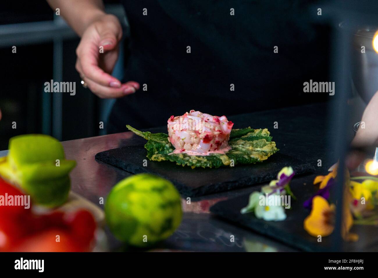 two people preparing food with ingredients on the counter dark light ...