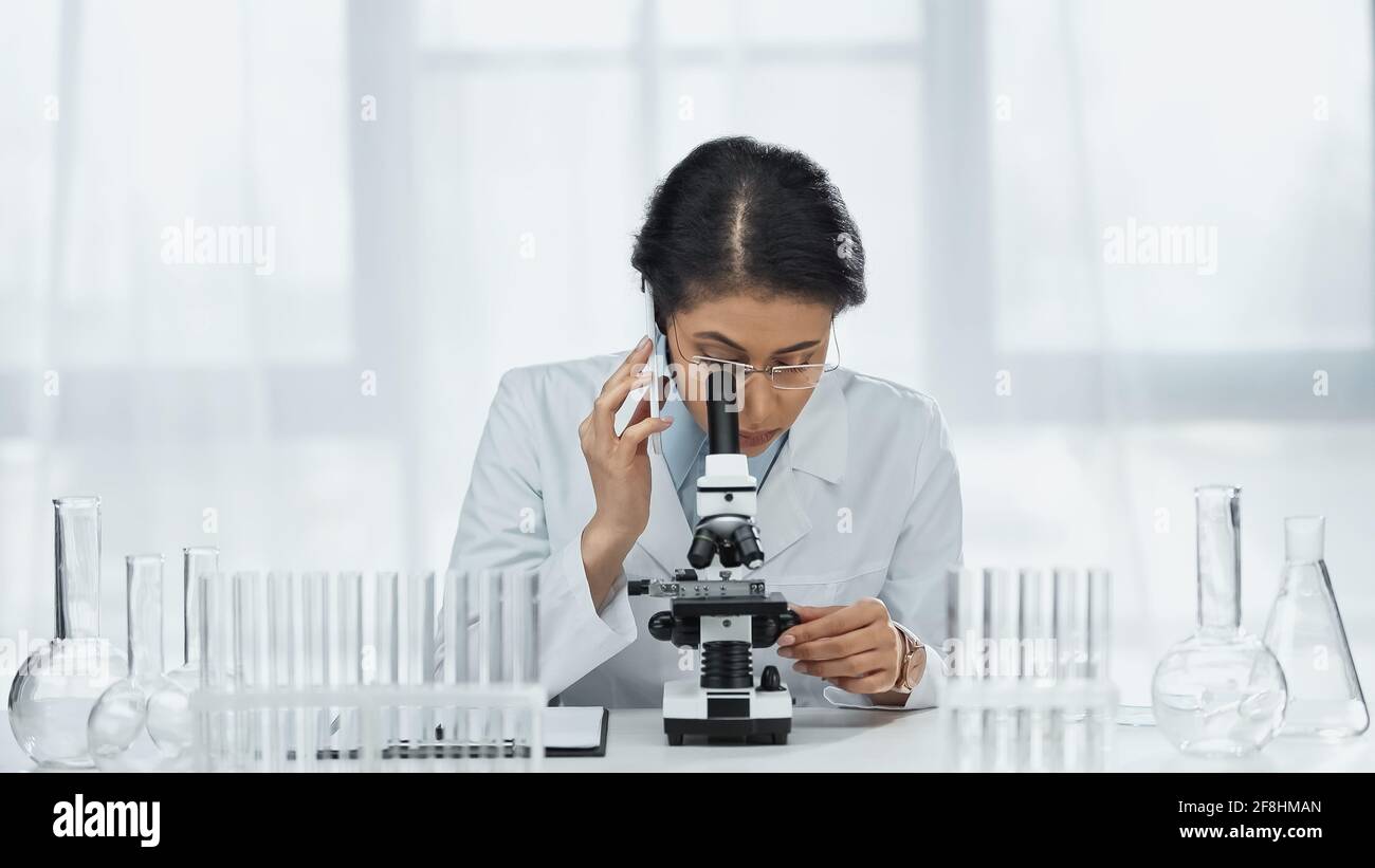 Black woman looking through microscope hi-res stock photography and ...