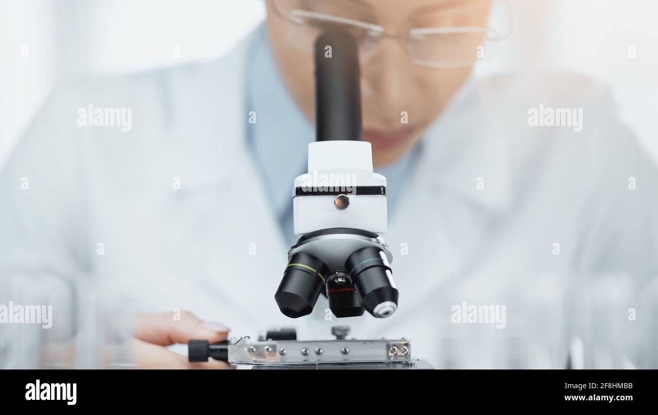 blurred african american scientist looking through microscope Stock ...