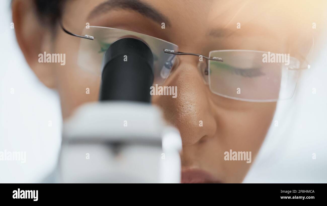 Black woman looking through microscope hi-res stock photography and ...