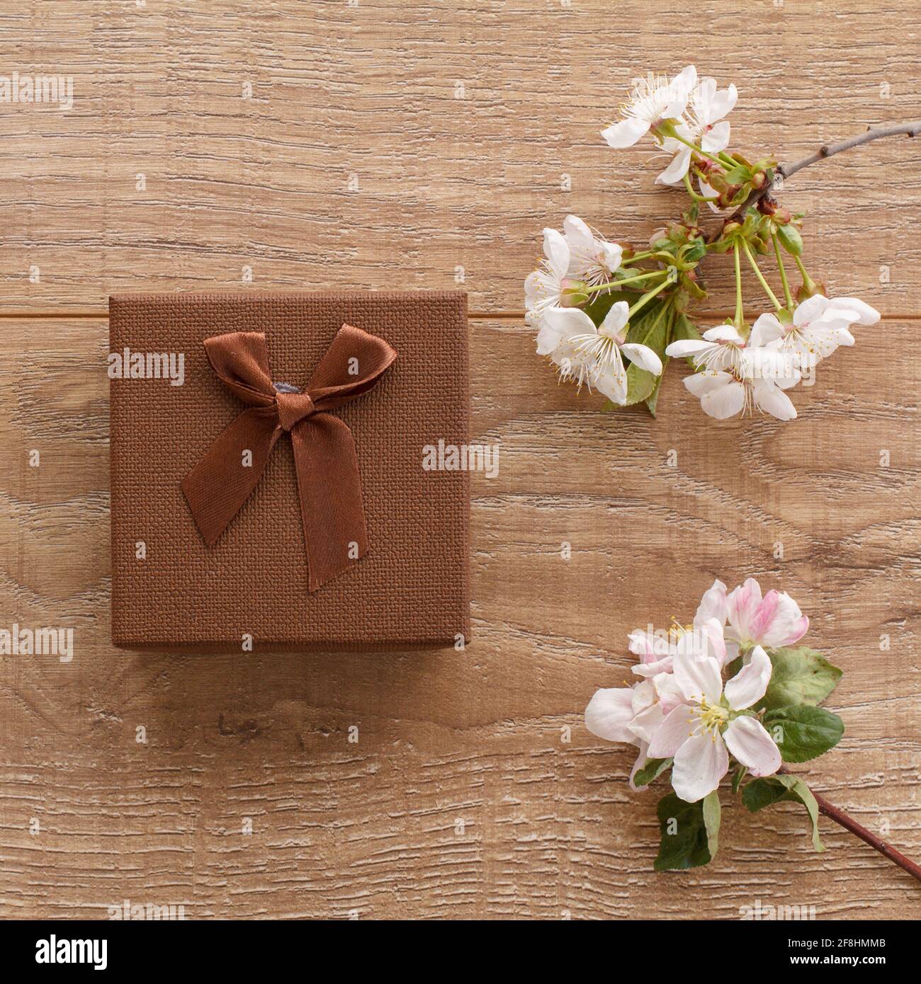 Brown gift box with branches of flowering cherry and apple trees on the ...
