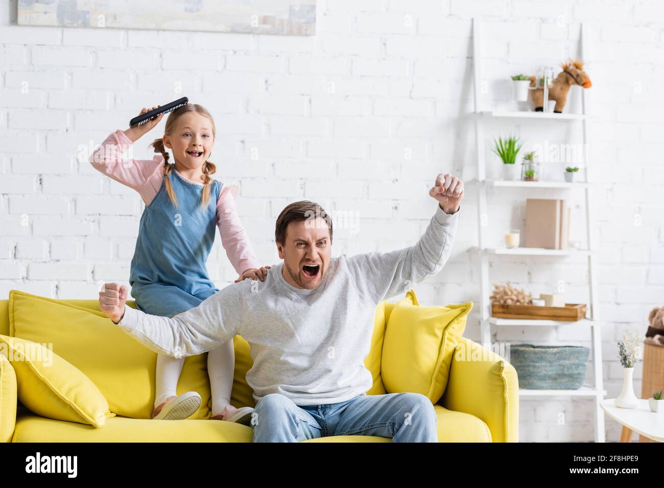 excited man shouting and showing win gesture while watching tv with ...