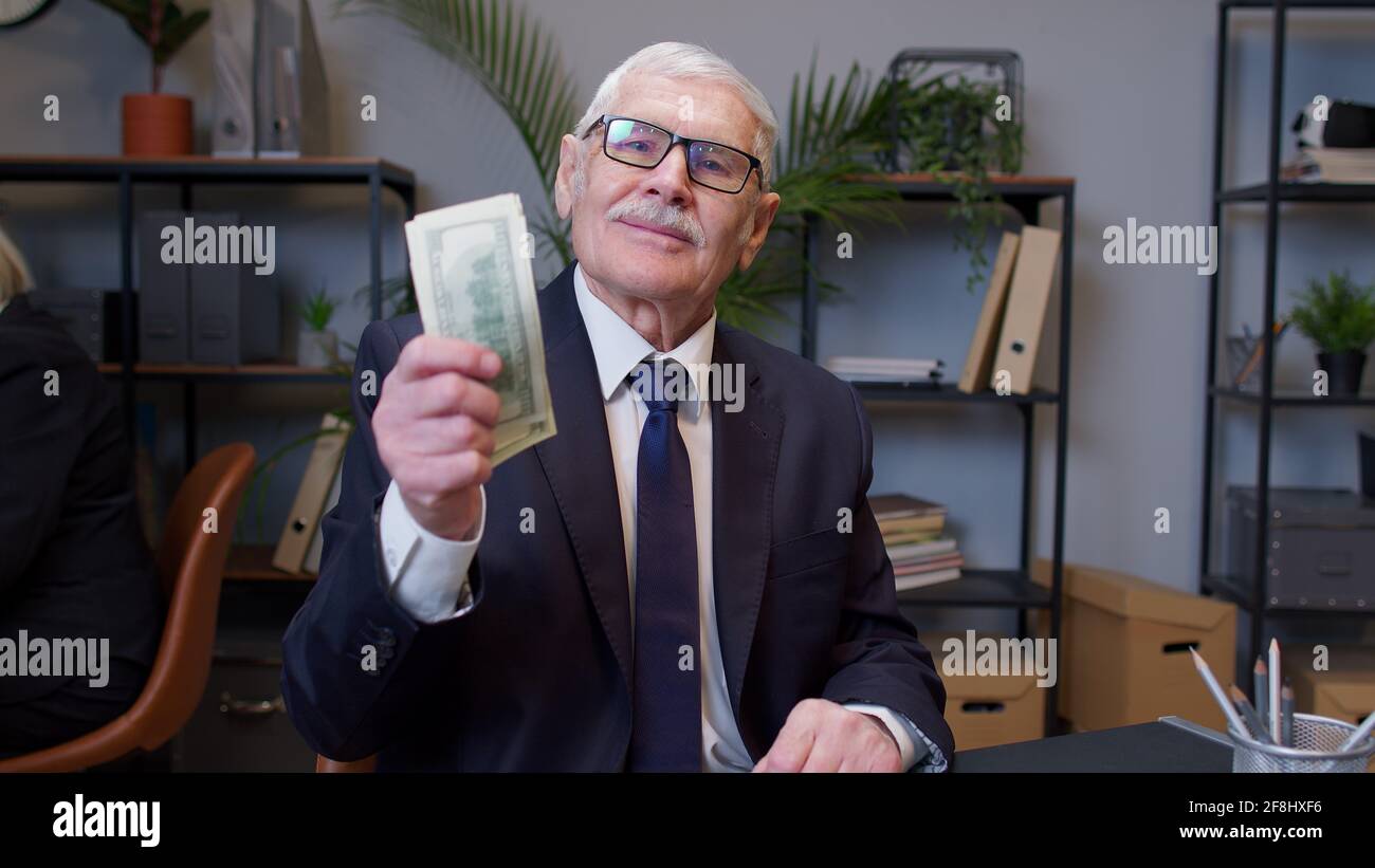 Rich senior business manager counting money dollar cash after working ...