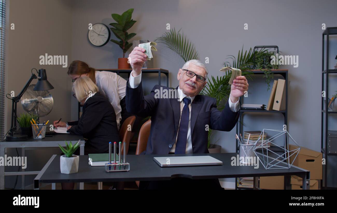 Elderly man boss celebrating business success dancing with money dollar ...