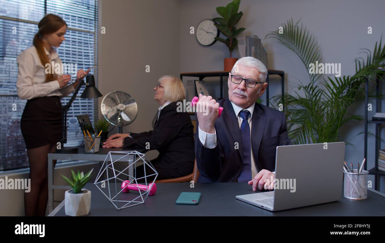 Business man making fitness dumbbells exercises after hard work while ...