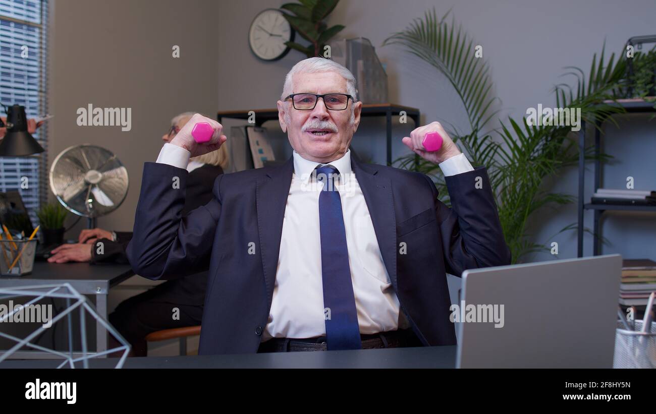 Business man making fitness dumbbells exercises after hard work while ...