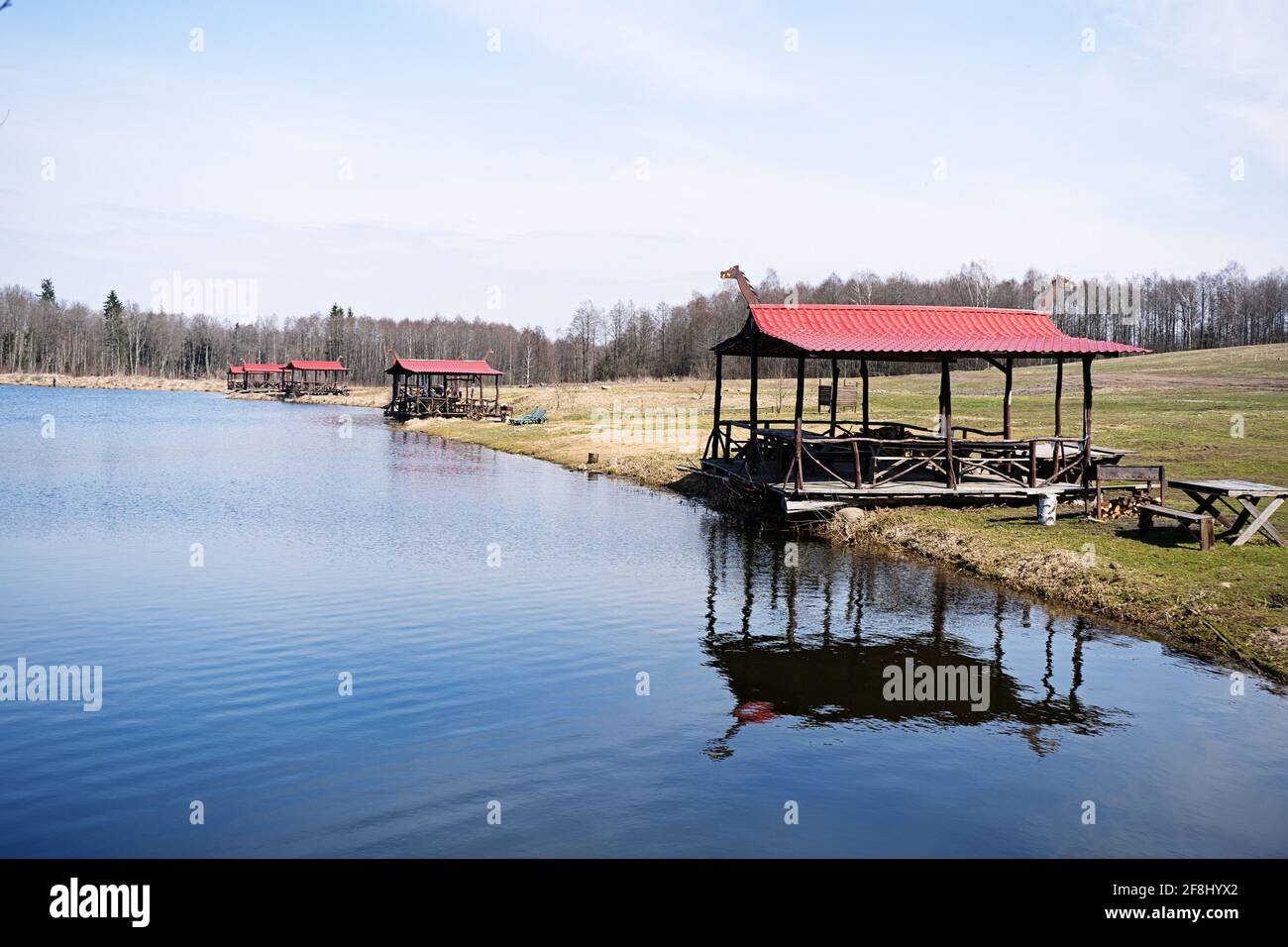 gazebos with a red roof on the shore of a spring lake Stock Photo - Alamy