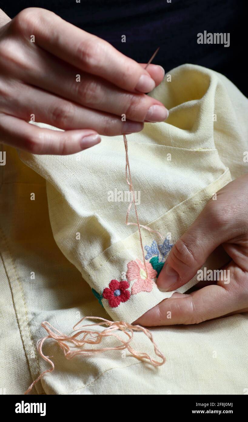 Embroidery in woman hands, female doing flower pattern embroidery on ...