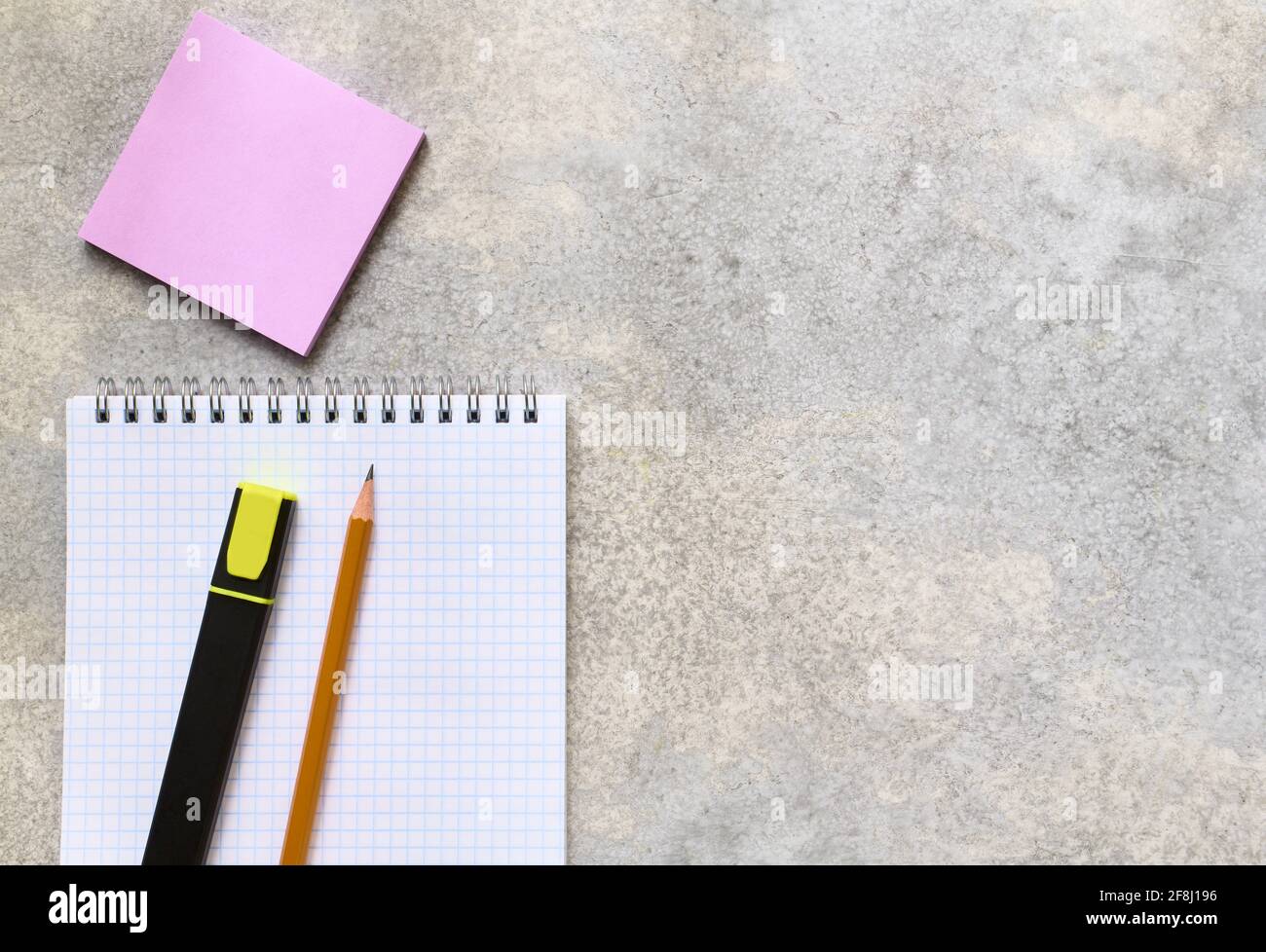 Open notebook, pencil and marker on gray background with copy space ...
