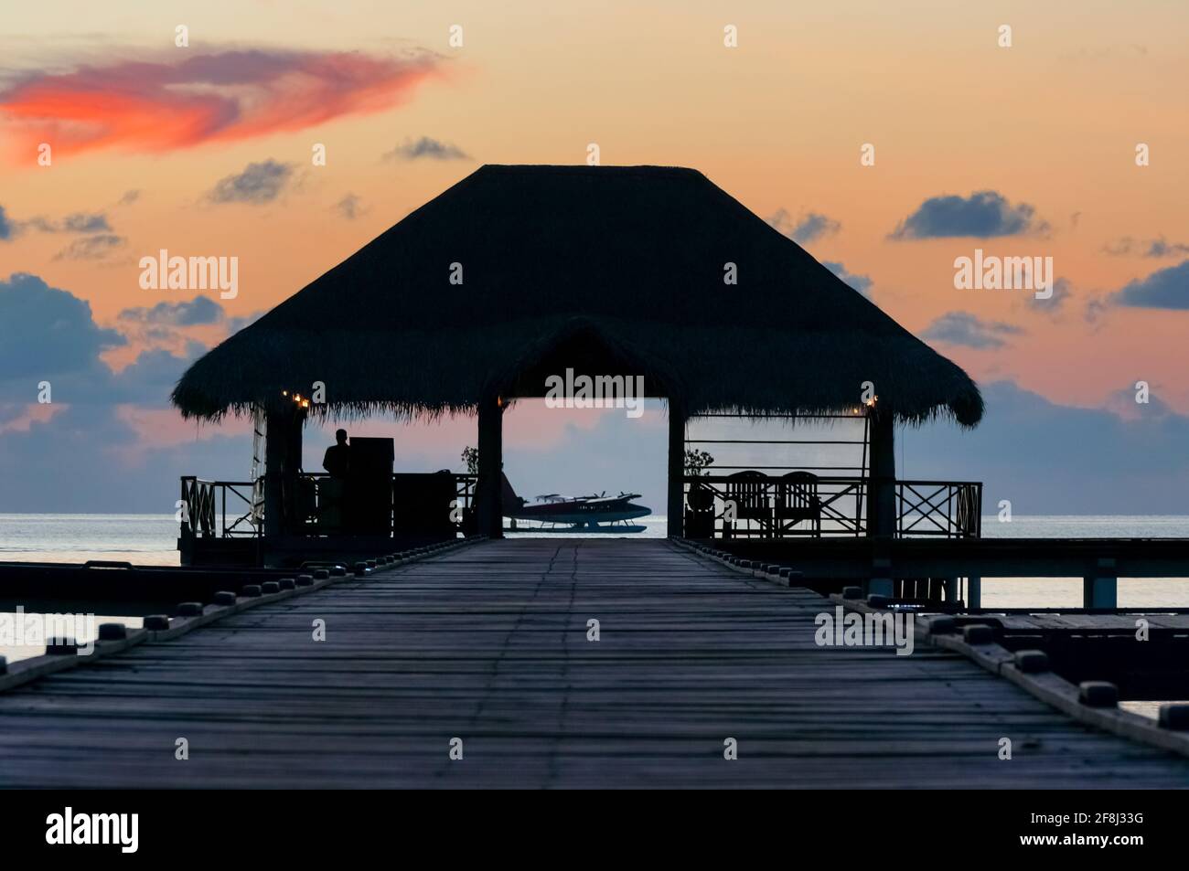 landing of a seaplane on the maldivian lagoon at sunset. luxurious ...