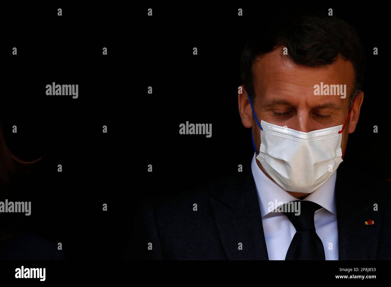 French President Emmanuel Macron, wearing a protective face mask ...