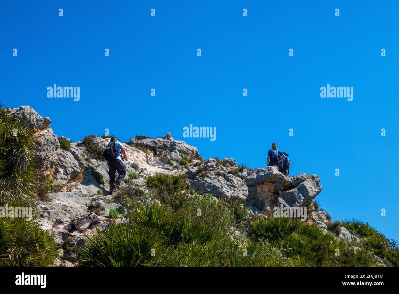 Group of people mountaineer standing atop of rock Stock Photo - Alamy