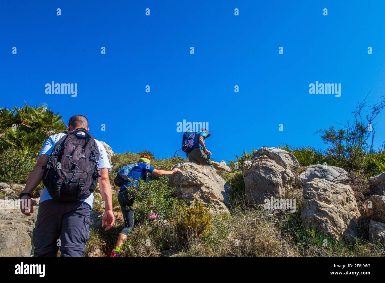 Group of people mountaineer standing atop of rock Stock Photo - Alamy