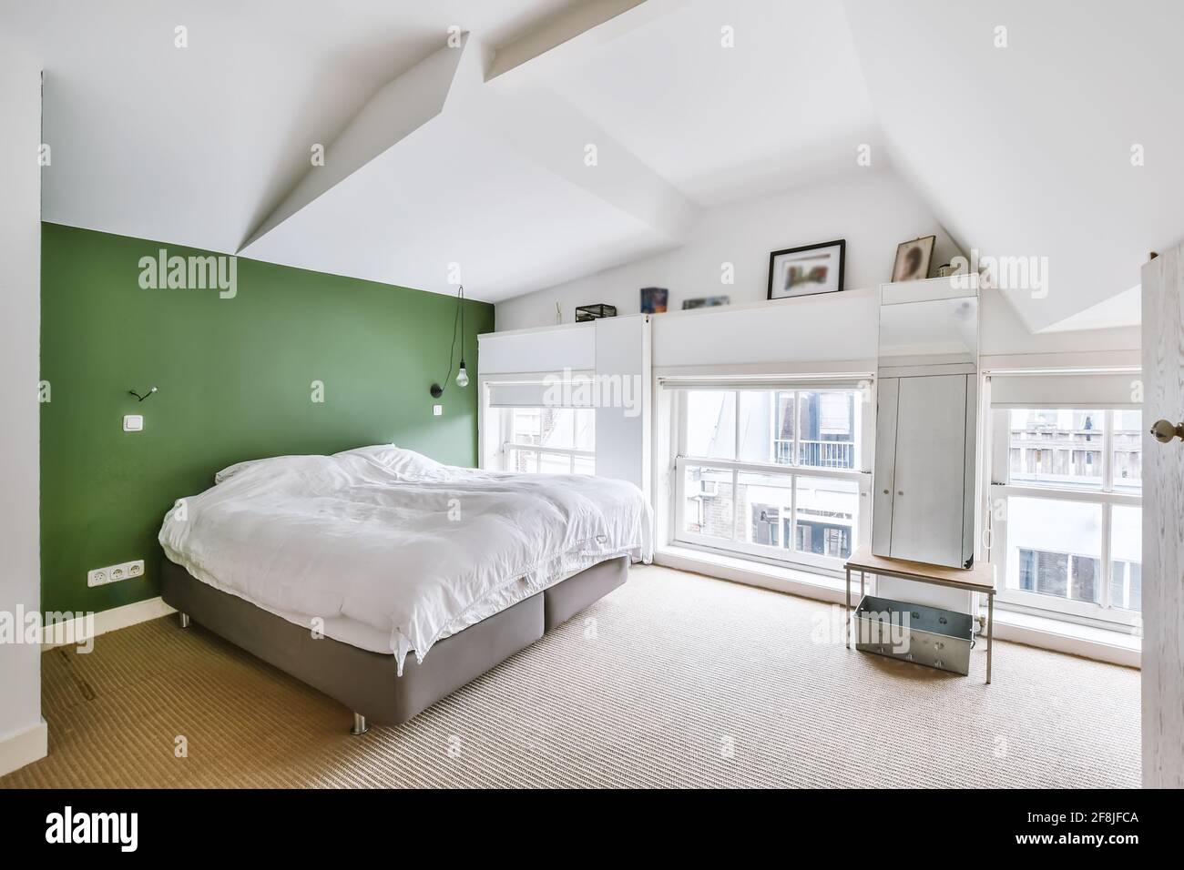 Mansard bedroom with minimalist interior design Stock Photo - Alamy