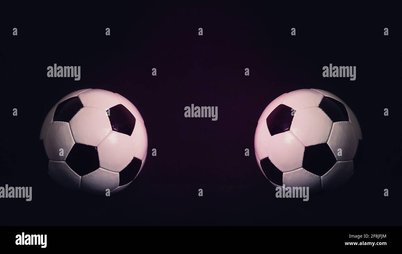 Two classic soccer balls, one in front another, isolated on a black ...