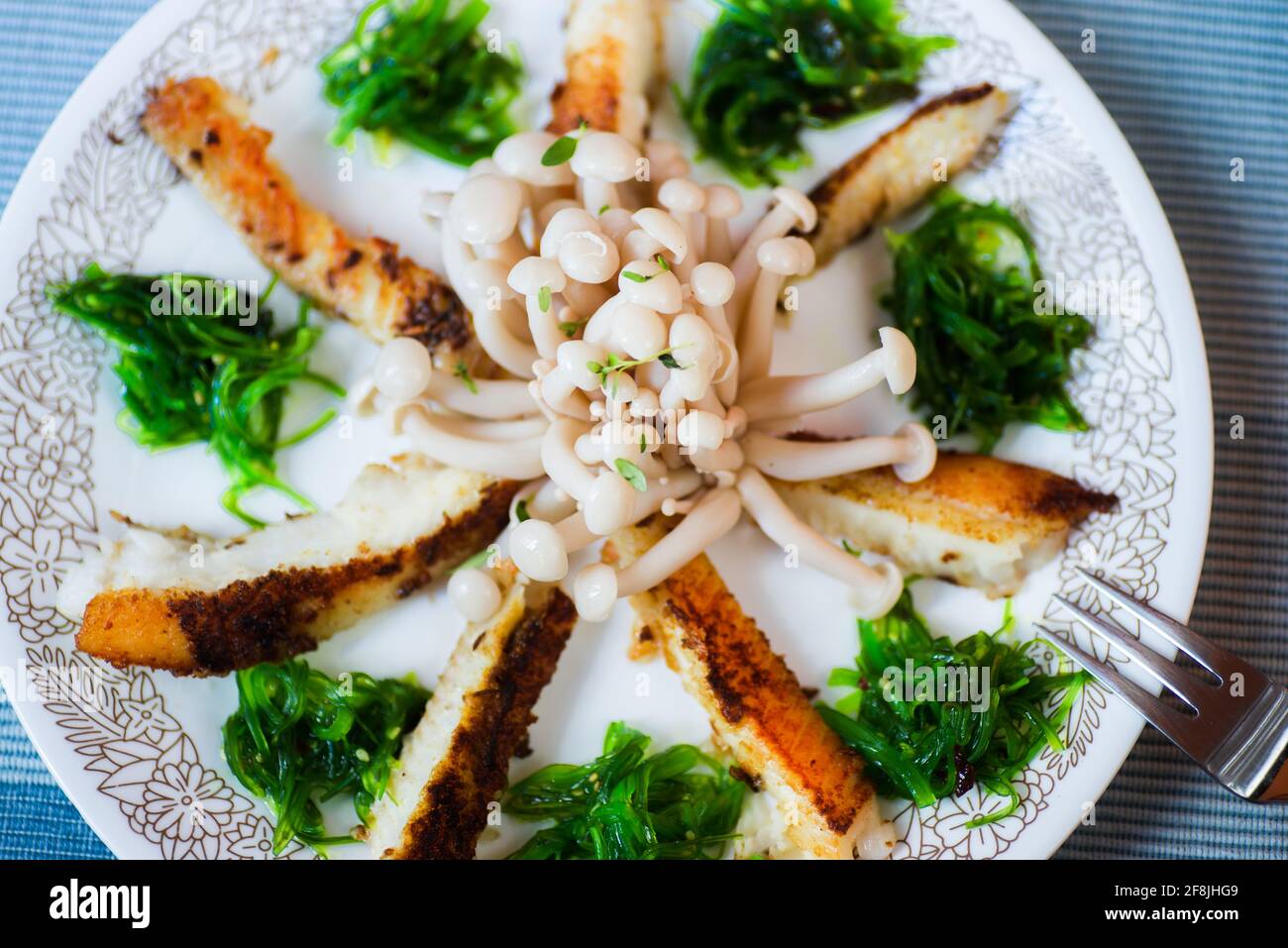Sliced fried fish, bunch of shimeji mushroom, boiled green seaweed with ...
