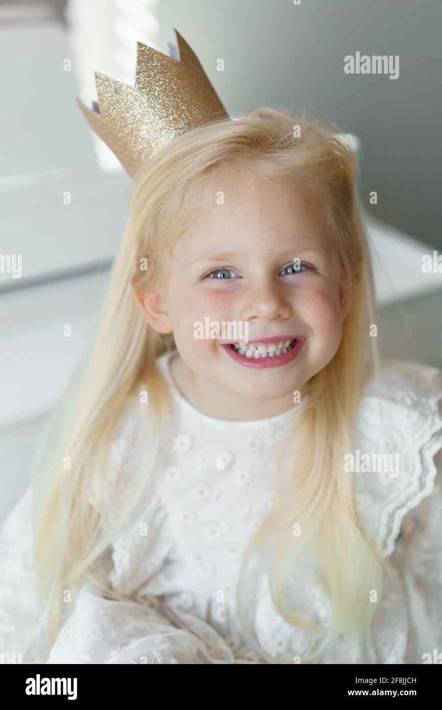 Happy blond girl smiling wearing golden crown Stock Photo - Alamy