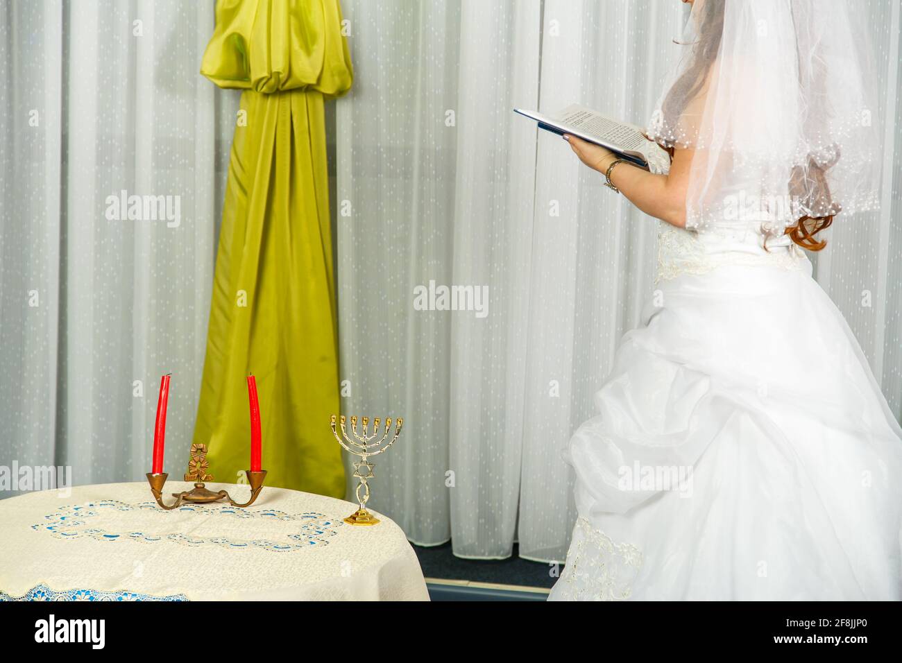 A Jewish bride stands by the window before the Hupa ceremony in a wedd ...