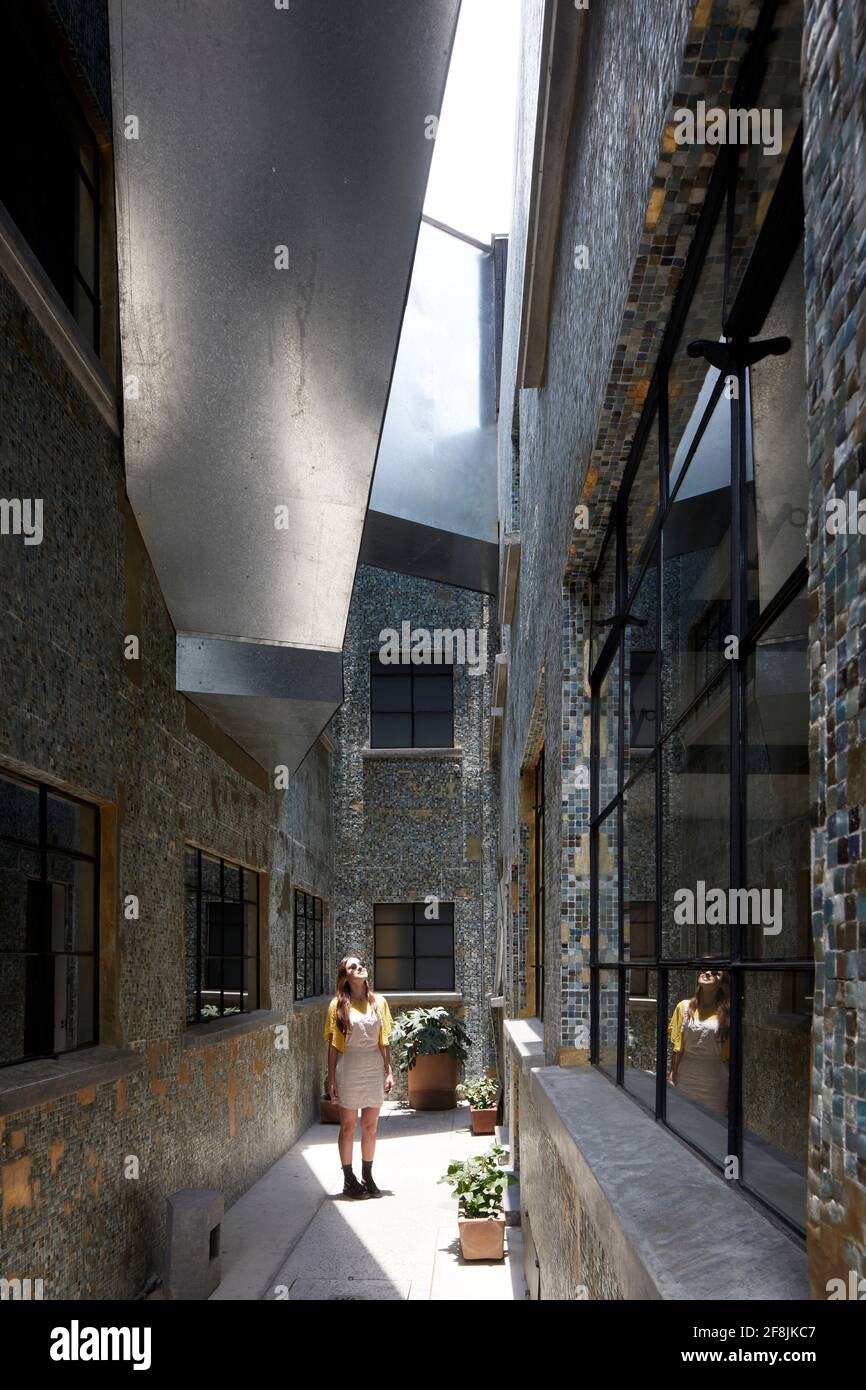 External side corridor with steel walkways with woman standing in path ...