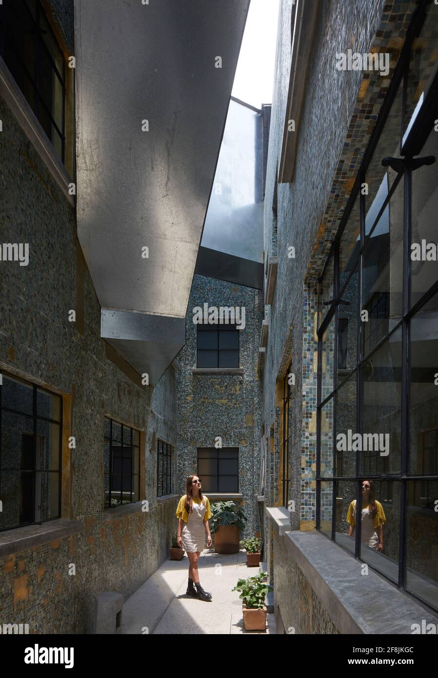 External side corridor with steel walkways with woman standing in path ...