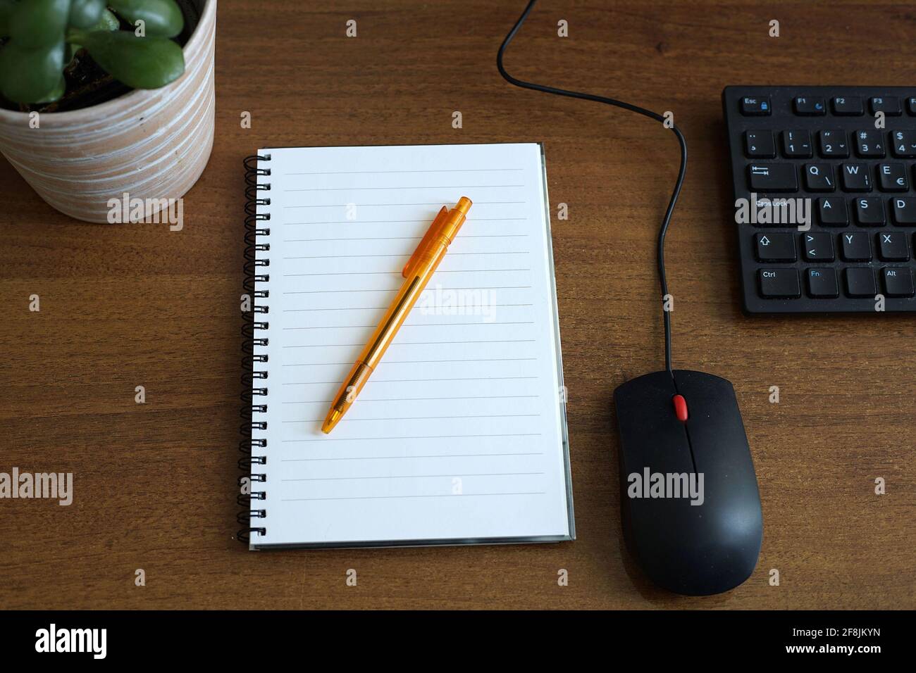 Shot of office table with notebook, pen, keyboard and mouse Stock Photo ...
