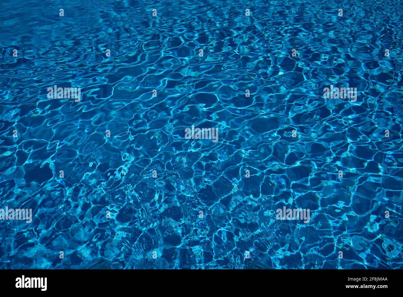 Close up of swimming pool water surface with sparkling light ...