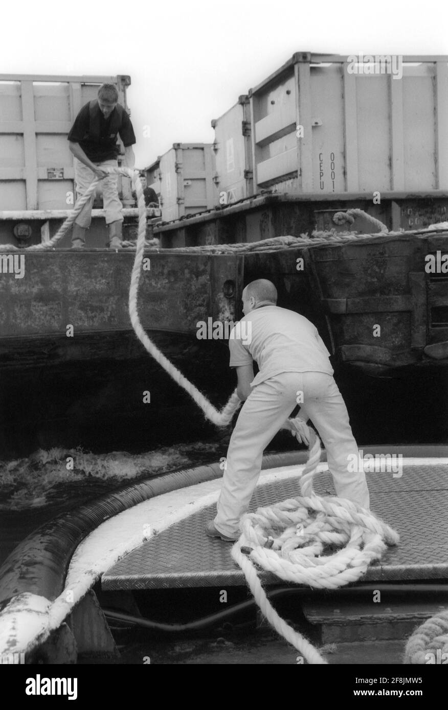 Lightermen of the River Thames using ropes to secure the barges for ...