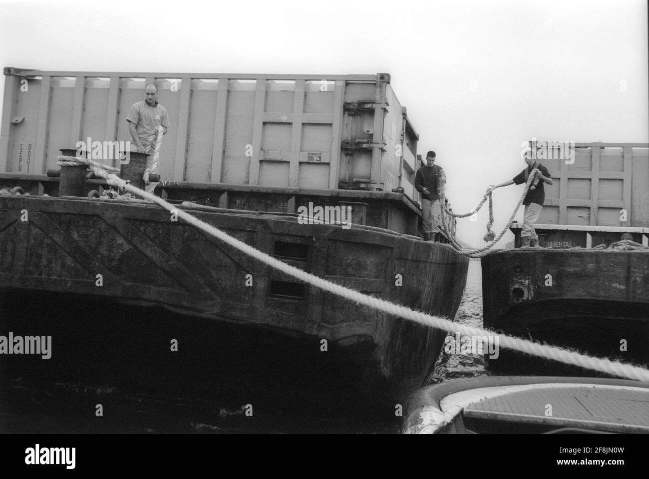 Lightermen of the River Thames using ropes to secure the barges for ...