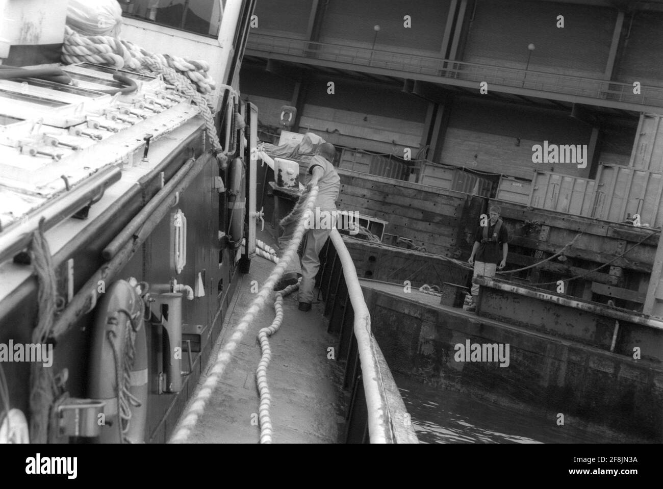 Lightermen of the River Thames using ropes to secure the barges for ...
