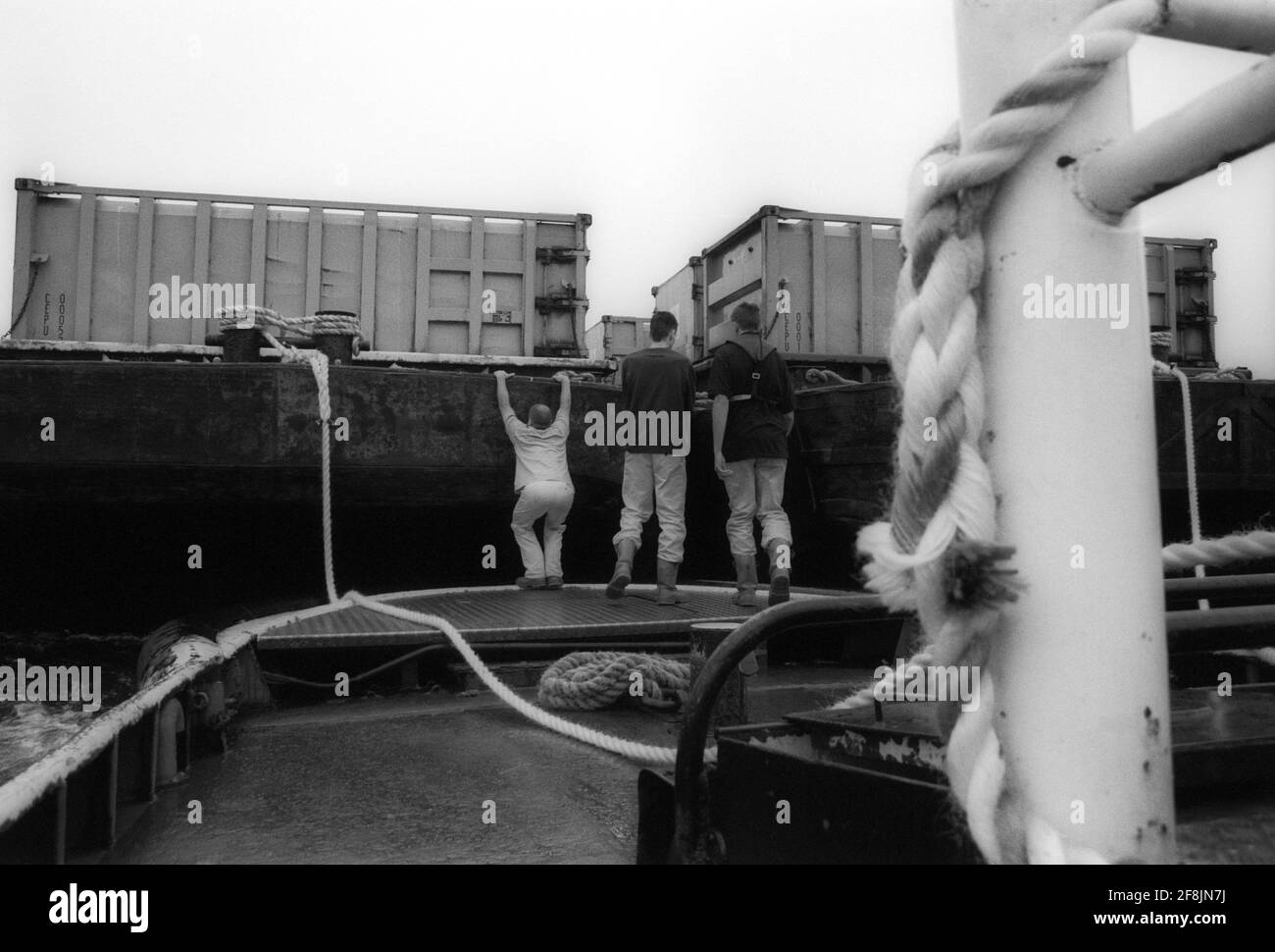 Lightermen of the River Thames using ropes to secure the barges for ...