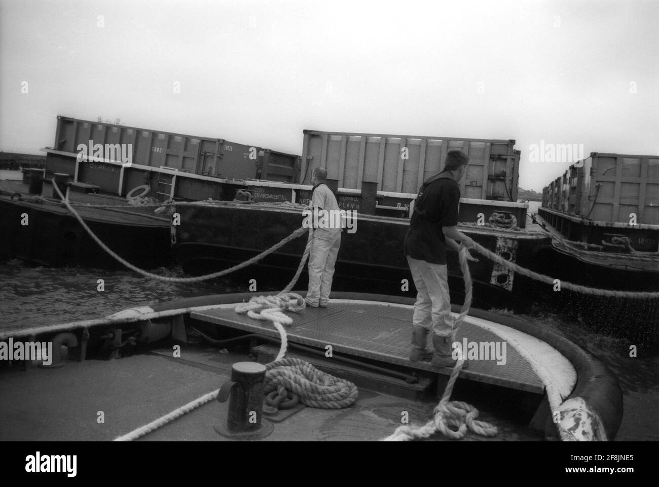 Lightermen of the River Thames using ropes to secure the barges for ...