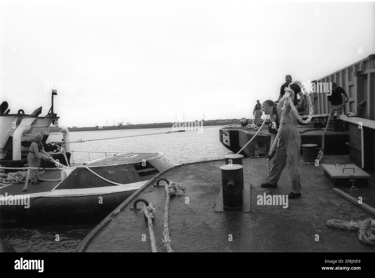 Lightermen of the River Thames using ropes to secure the barges for ...