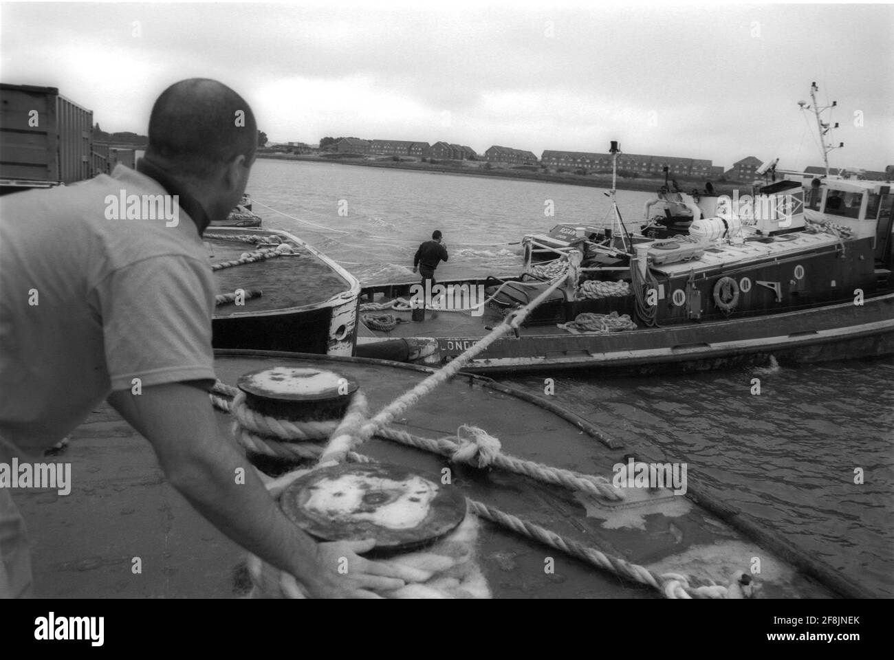 Lightermen of the River Thames using ropes to secure the barges for ...