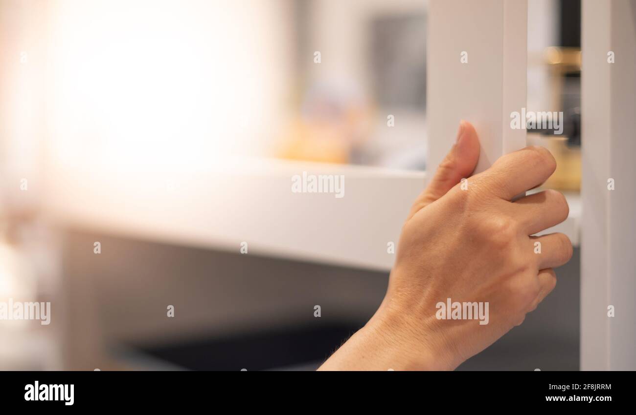 Close up female hand pushing on the position for open white wood ...