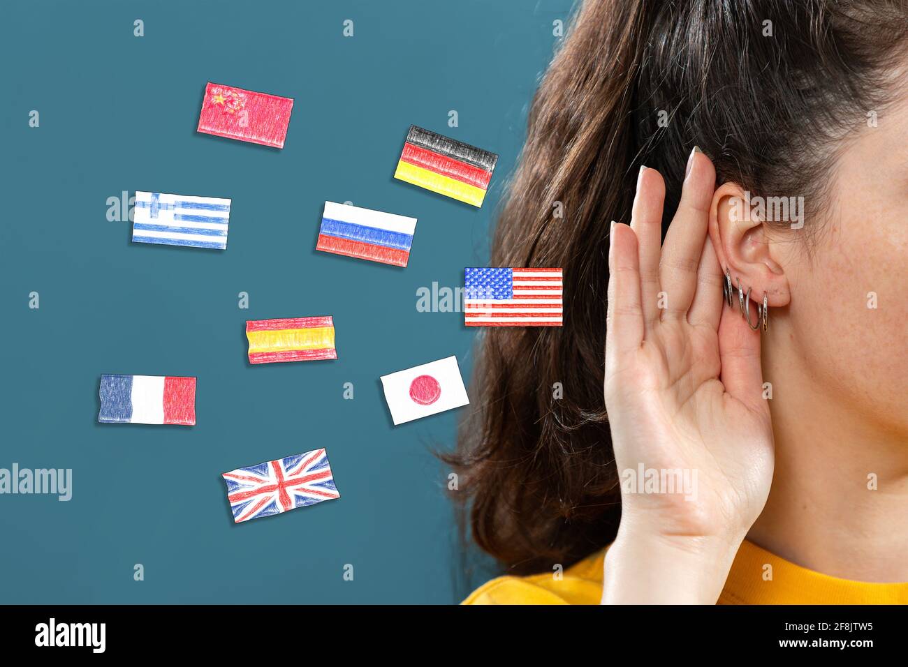 Woman put her hand to her ear, into which the flags of different ...
