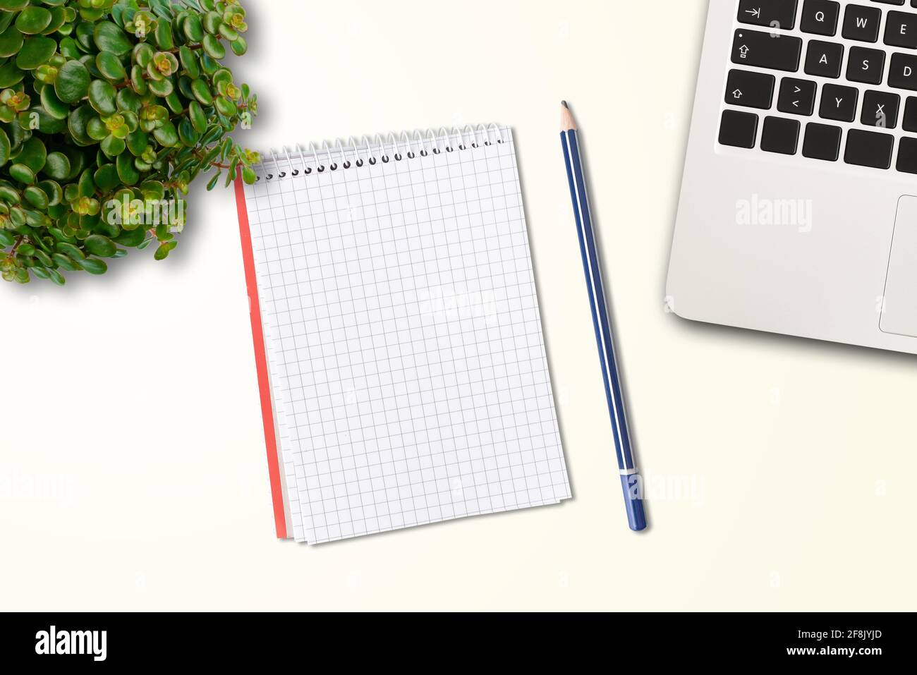 directly above view of small spiral notepad and pencil, laptop computer ...