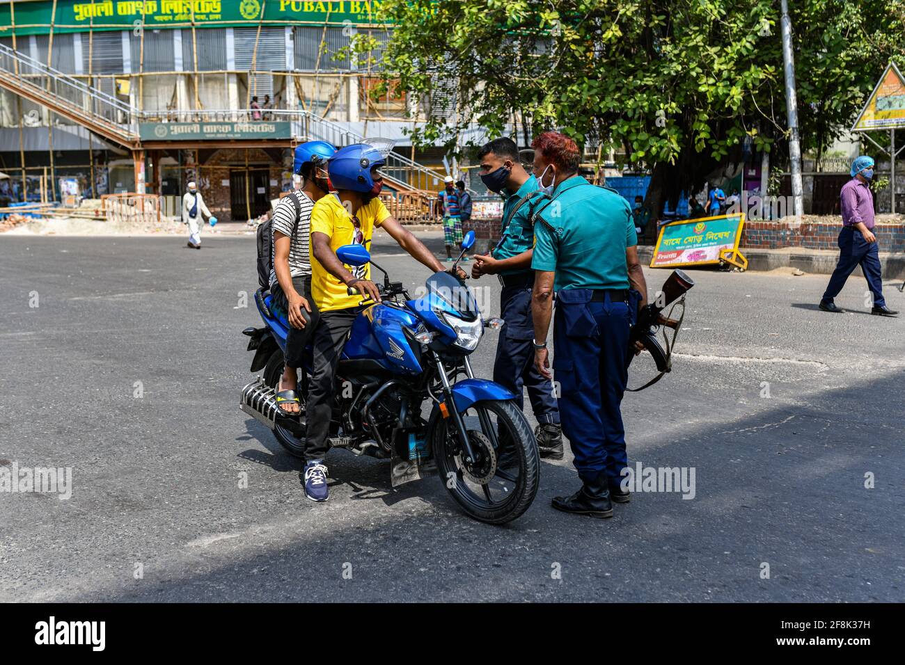 Bangladeshi police officers stop a motorist at a checkpoint as ...