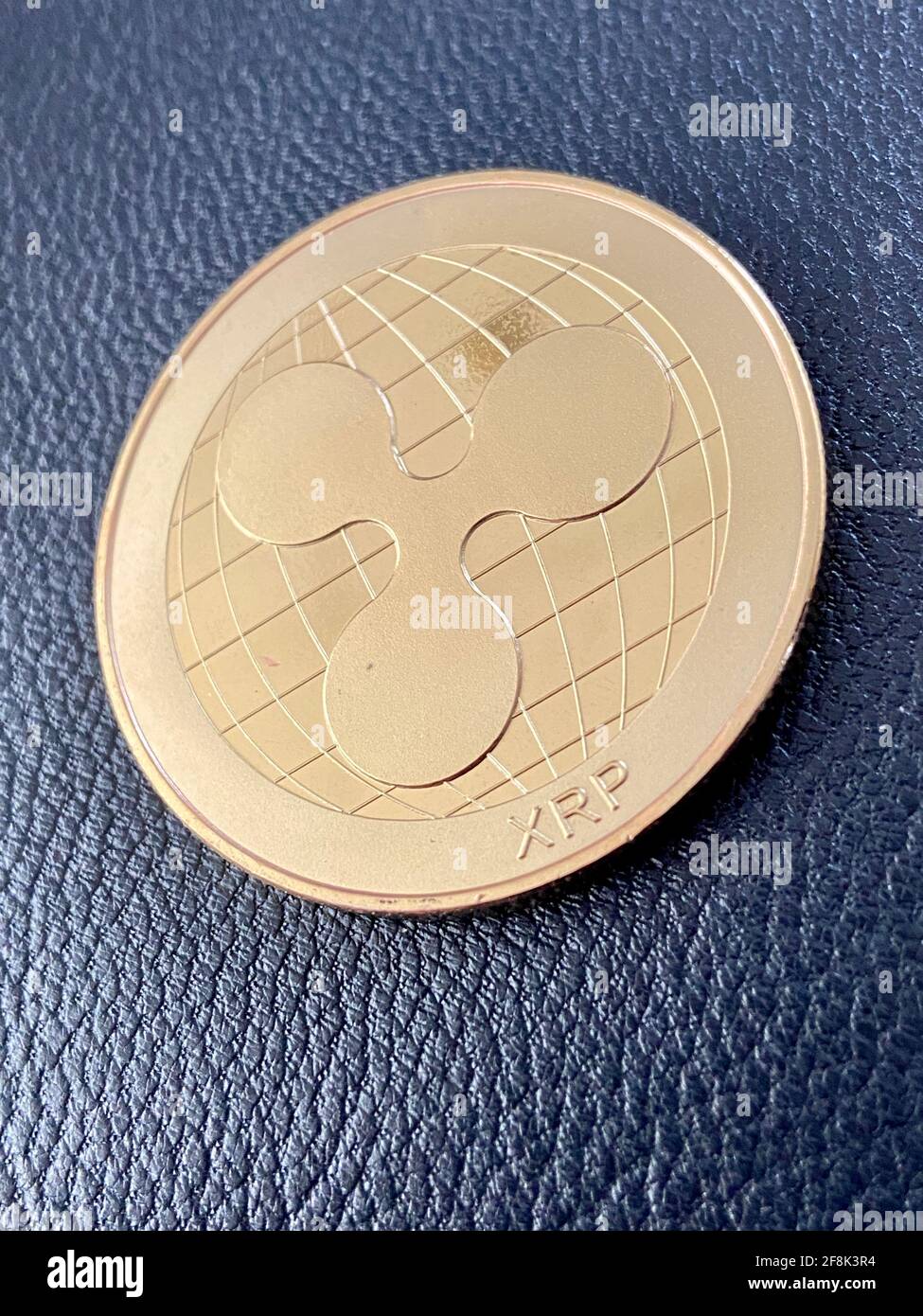 Golden xrp ripple coin on silver metal background, xrp ripple is a ...
