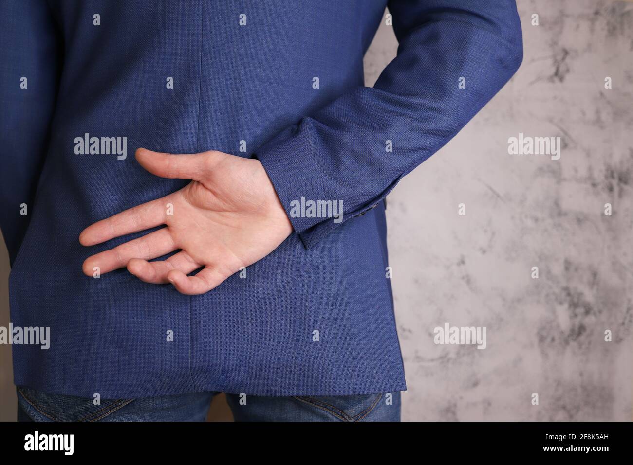 man in blue business suit holds empty hand behind back Stock Photo - Alamy
