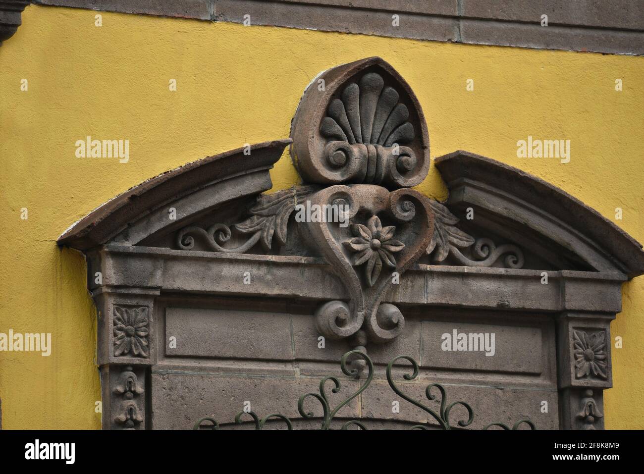 Stone crafted facade pediment on an ochre wall of the Baroque style ...