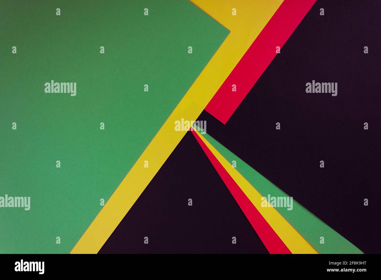 Red, yellow and green color paper on the black background. Black ...