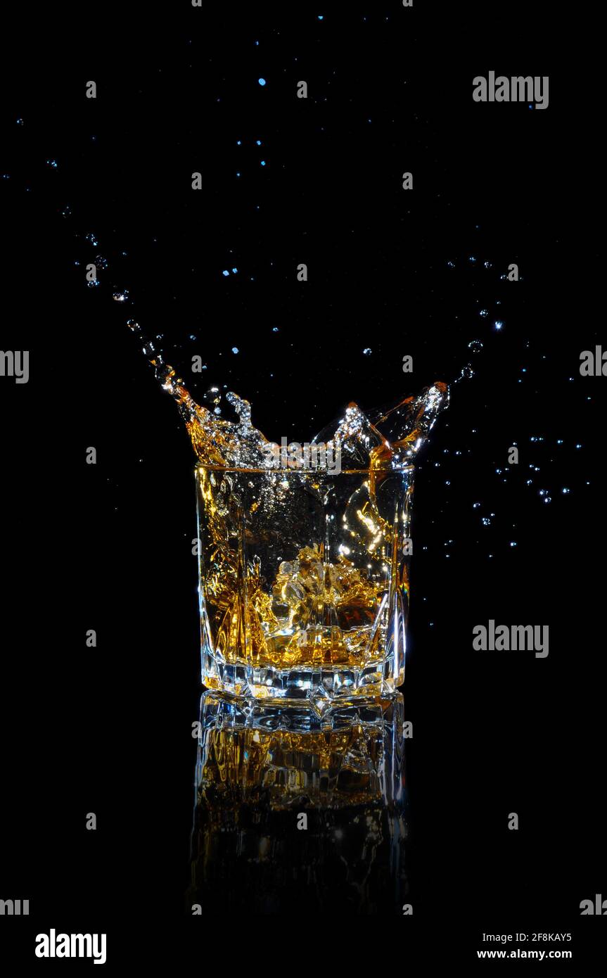 Whiskey with splash isolated on black background. Alcoholic beverage ...